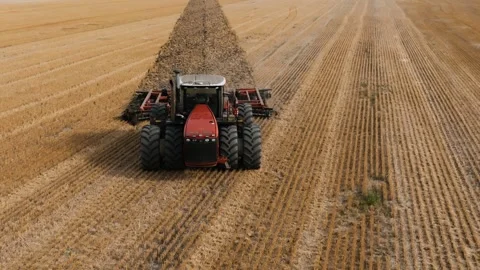 Disking the field. Big red Tractor culti... | Stock Video | Pond5