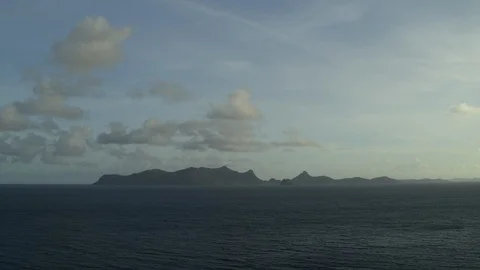Distant island in ocean under blue sky a... | Stock Video | Pond5