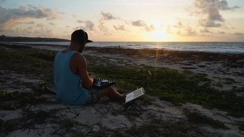 DJ sitting on a beach, playing with disc... | Stock Video | Pond5