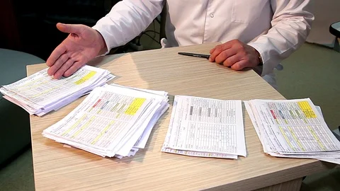Doctor and a stack of test results | Stock Video | Pond5