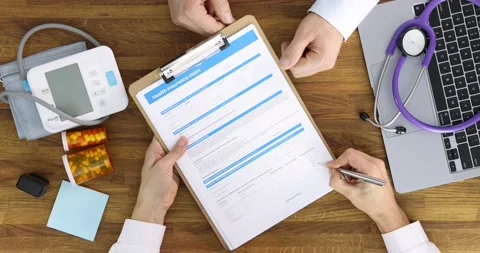 Doctor fills out health insurance claim ... | Stock Video | Pond5