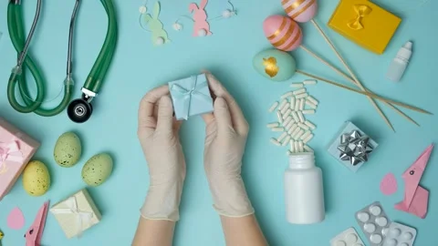 Doctor holding an Easter gift in his glo... | Stock Video | Pond5