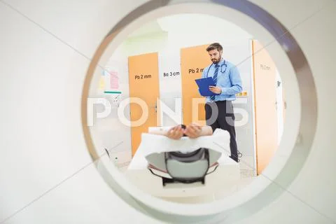 Photograph: Doctor reviewing chart of patient about to have mri scan at ...