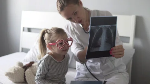 The doctor shows the little girl an X-ra... | Stock Video | Pond5