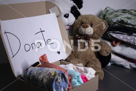 'Donate' sign handwritten with black letters. A box with clothes and a ...