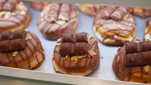 Donuts with chocolate bars on top displa... | Stock Video | Pond5