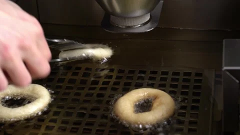 Donuts frying in boiling oil. Process of... | Stock Video | Pond5