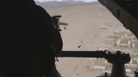 Door gunner firing machine gun at buildi... | Stock Video | Pond5
