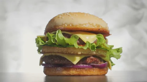double cheeseburger rotating on table on... | Stock Video | Pond5