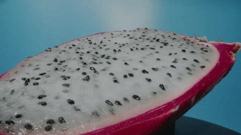 Dragon fruit (Pitaya) slice on blue back... | Stock Video | Pond5