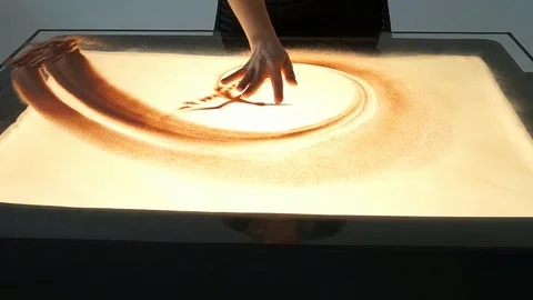Drawing with sand. Drawing sand on a whi... | Stock Video | Pond5