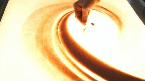 Drawing with sand. Drawing sand on a whi... | Stock Video | Pond5