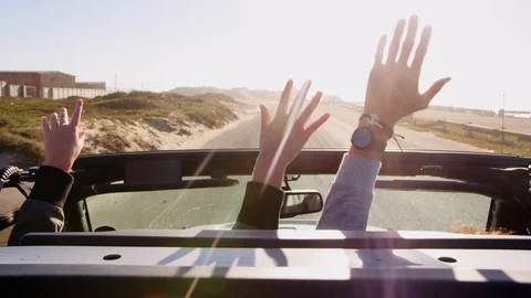 Driving couple reaching hands through su... | Stock Video | Pond5