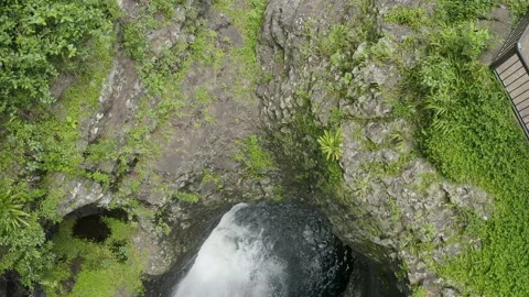 Drone reveal of waterfall dig into Rock ... | Stock Video | Pond5