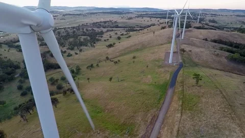 Drone tracks back from wind farm to reve... | Stock Video | Pond5