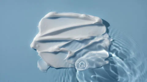 Drop falls down on water on blue backgro... | Stock Video | Pond5