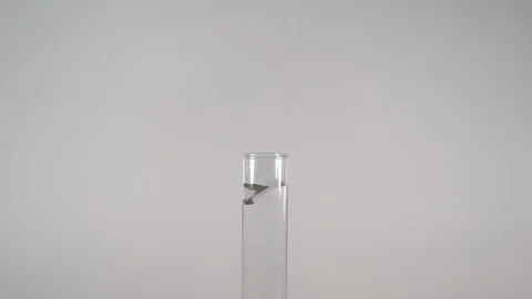 Drop of liquid falling into test tube in... | Stock Video | Pond5