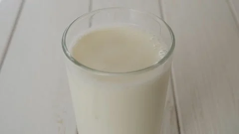 A drop of milk falling into a full glass... | Stock Video | Pond5