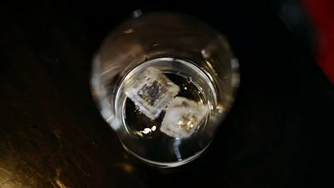 Dropping ice cubes in the glass with bla... | Stock Video | Pond5