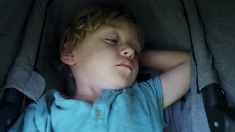 Drowsy little boy sitting inside strolle... | Stock Video | Pond5