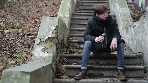 Drunk guy sitting on abandoned stairs in... | Stock Video | Pond5