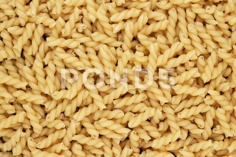 Dry uncooked thick gemelli pasta texture background ~ Hi Res #55386283