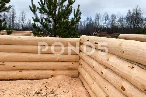 Drying and assembly of wooden log house at a construction base ...