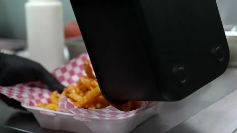 Dumping French fries in to a serving bas... | Stock Video | Pond5