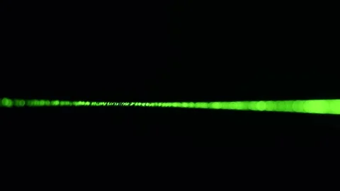 Dust particles in green laser light beam... | Stock Video | Pond5