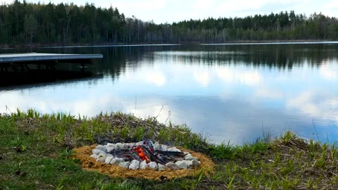Dying Campfire on Lake Shore with Wind | Stock Video | Pond5