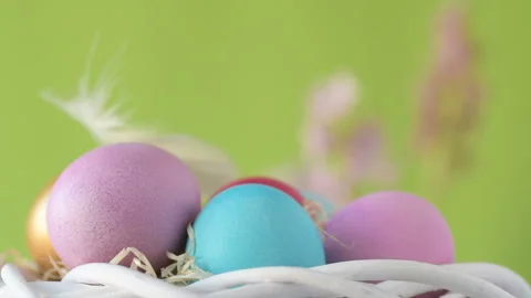 Easter eggs in straw spin on green backg... | Stock Video | Pond5