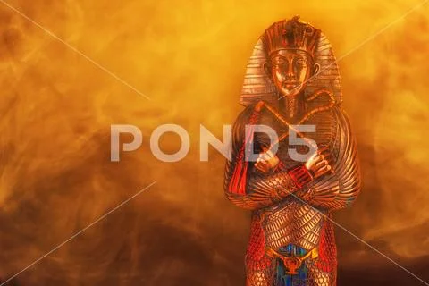 Photograph: Egyptian pharaoh figurine in yellow smoke on a black ...