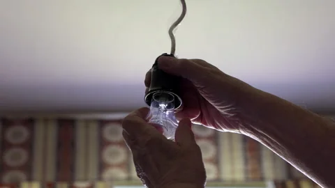 An Elderly Man Is Changing A Light Bulb ... | Stock Video | Pond5