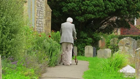 Elderly man walking through cemetery or ... | Stock Video | Pond5