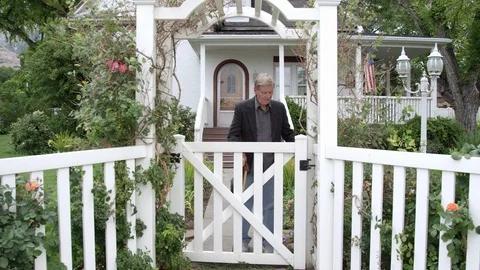 Elderly man walking through gate in his ... | Stock Video | Pond5