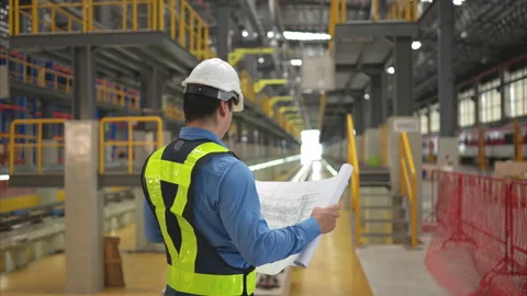 Electric vehicle engineer with blueprint... | Stock Video | Pond5