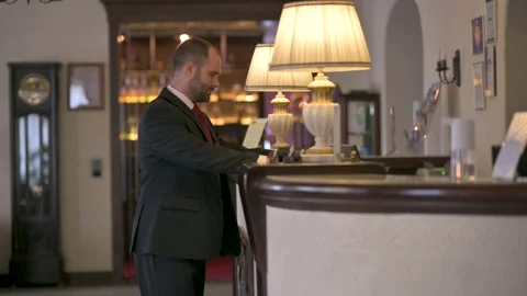 An elegant young man stands at the recep... | Stock Video | Pond5