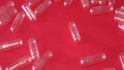 An empty capsule rotates on a red backgr... | Stock Video | Pond5