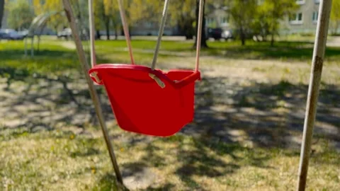 An empty red swing moves with the wind i... | Stock Video | Pond5
