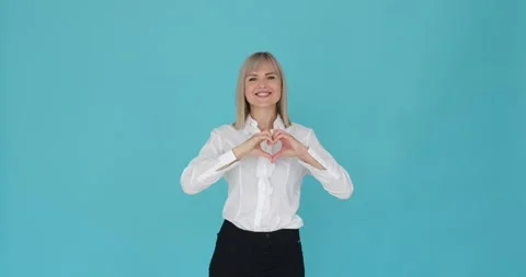 Enamored Woman Making Heart Shape on Blu... | Stock Video | Pond5