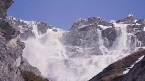 Enormous avalanche falling from a cliff ... | Stock Video | Pond5
