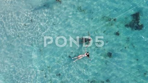 Erial view of two people floating in crystal-clear turquoise water ...