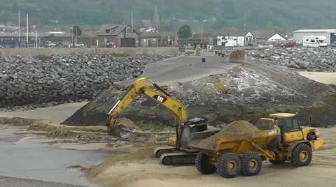 An excavator is digging up sand and is l... | Stock Video | Pond5