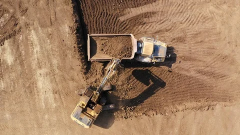 Excavator loading soil onto an Articulat... | Stock Video | Pond5
