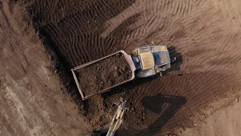 Excavator loading soil onto an Articulat... | Stock Video | Pond5