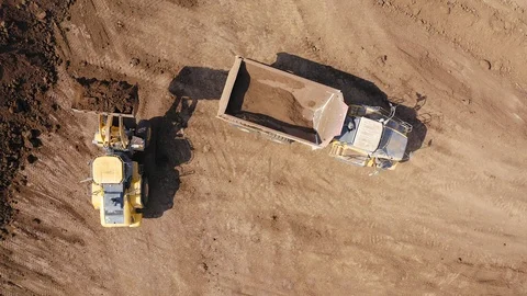 Excavator loading soil onto an Articulat... | Stock Video | Pond5