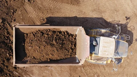 Excavator loading soil onto an Articulat... | Stock Video | Pond5