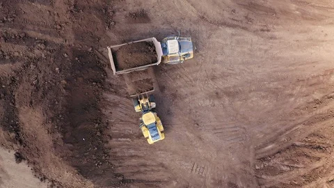 Excavator loading soil onto an Articulat... | Stock Video | Pond5