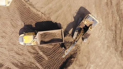 Excavator loading soil onto an Articulat... | Stock Video | Pond5