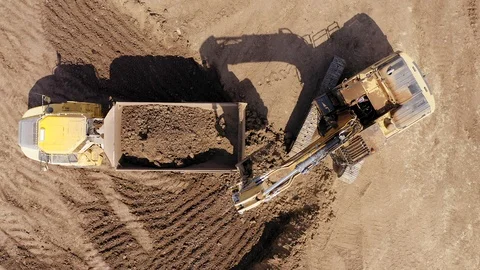 Excavator loading soil onto an Articulat... | Stock Video | Pond5